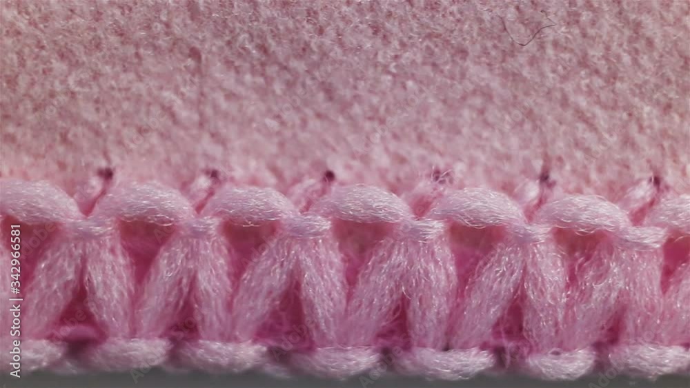 Overlock-treated edge of a very dense pink microfiber fabric. Real time ...