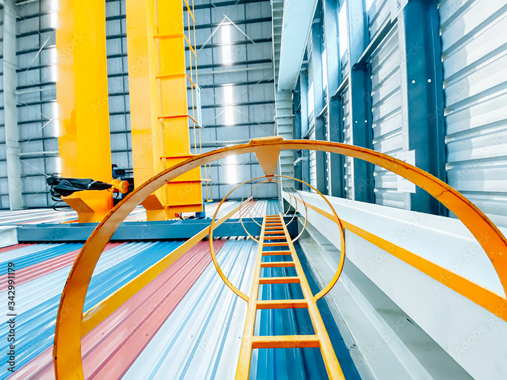 Overhead crane and fixed ladder inside factory building, industrial ...