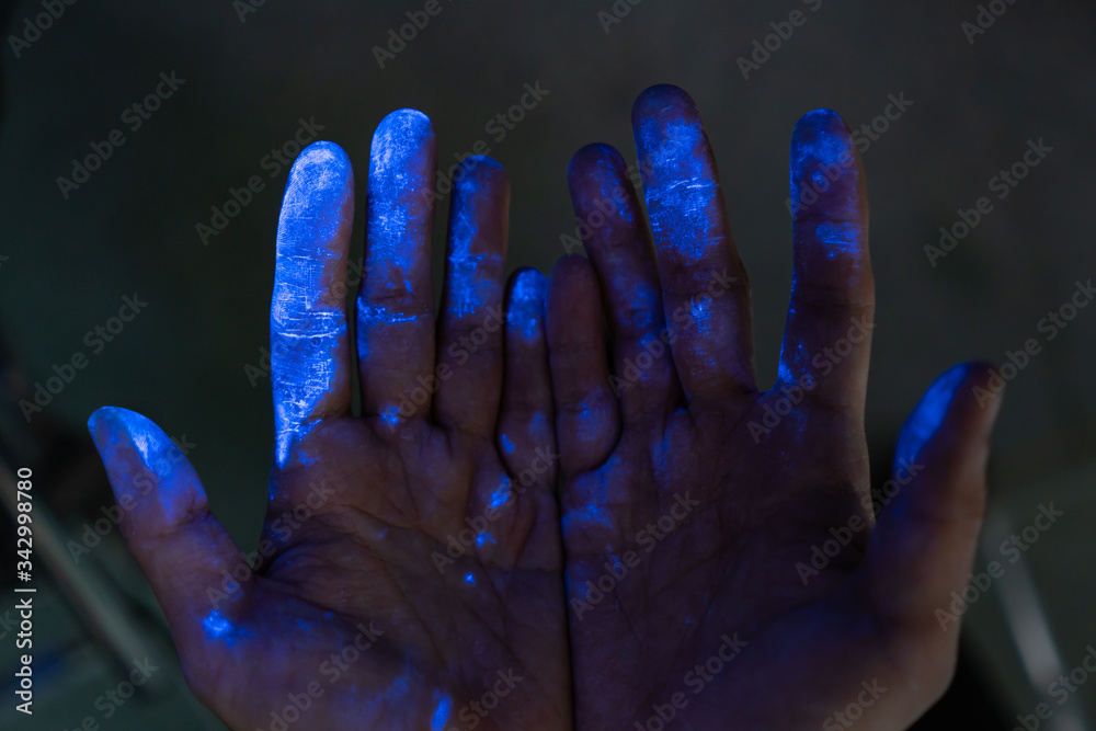 picture of hands covered with fluorescent tracking dust after touching ...