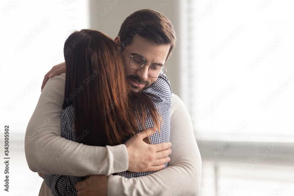 Handsome man embracing woman calms in difficult moment. Husband hugging ...