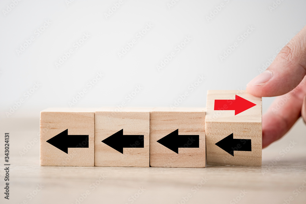 Hand flipping wooden cube block arrow from change left to right for ...