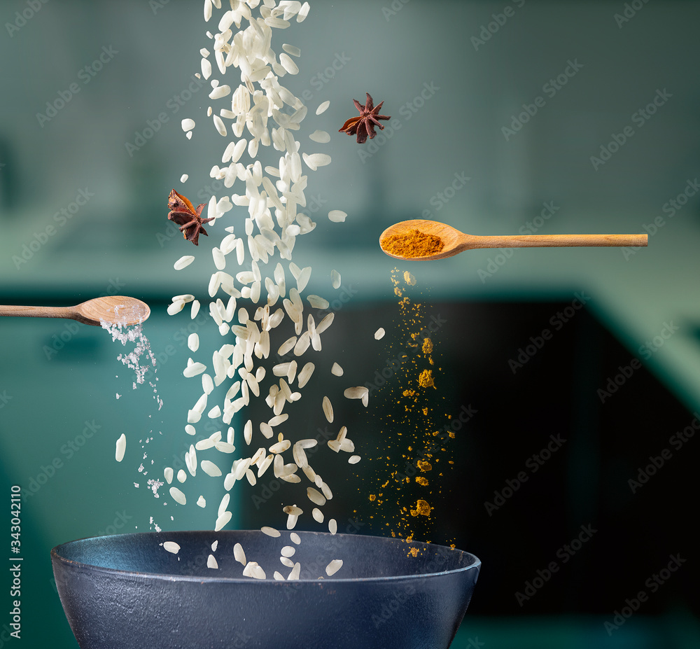 flying rice falls into a pot of boiling water. Salt, curry and star ...