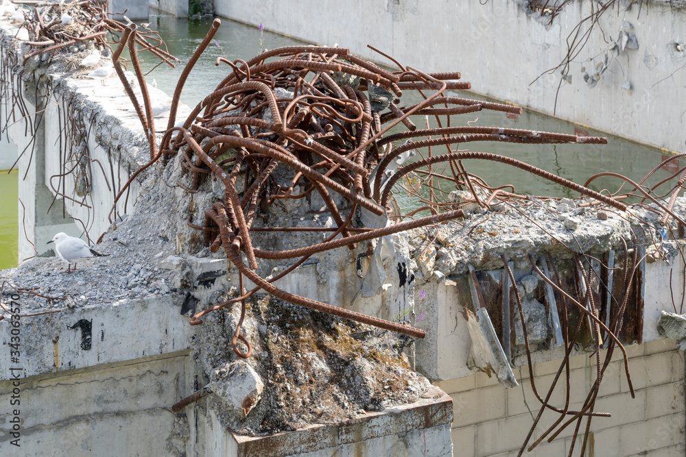 warped reinforcing steel at flooded ruins of collapsed concrete ...