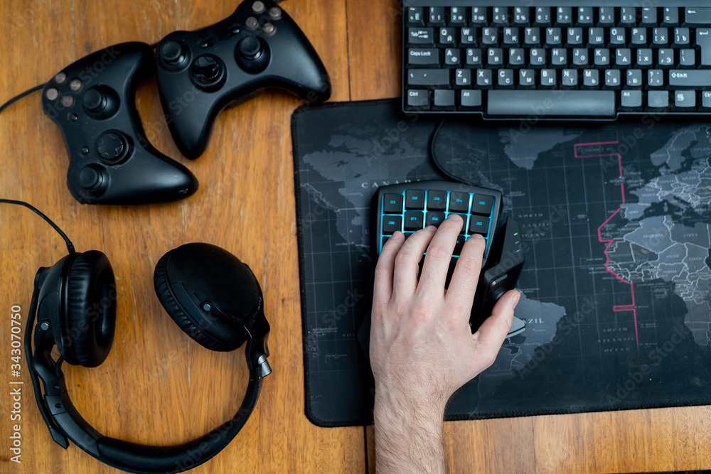 hand on keyboard on mouse pad background with world map. one gaming ...