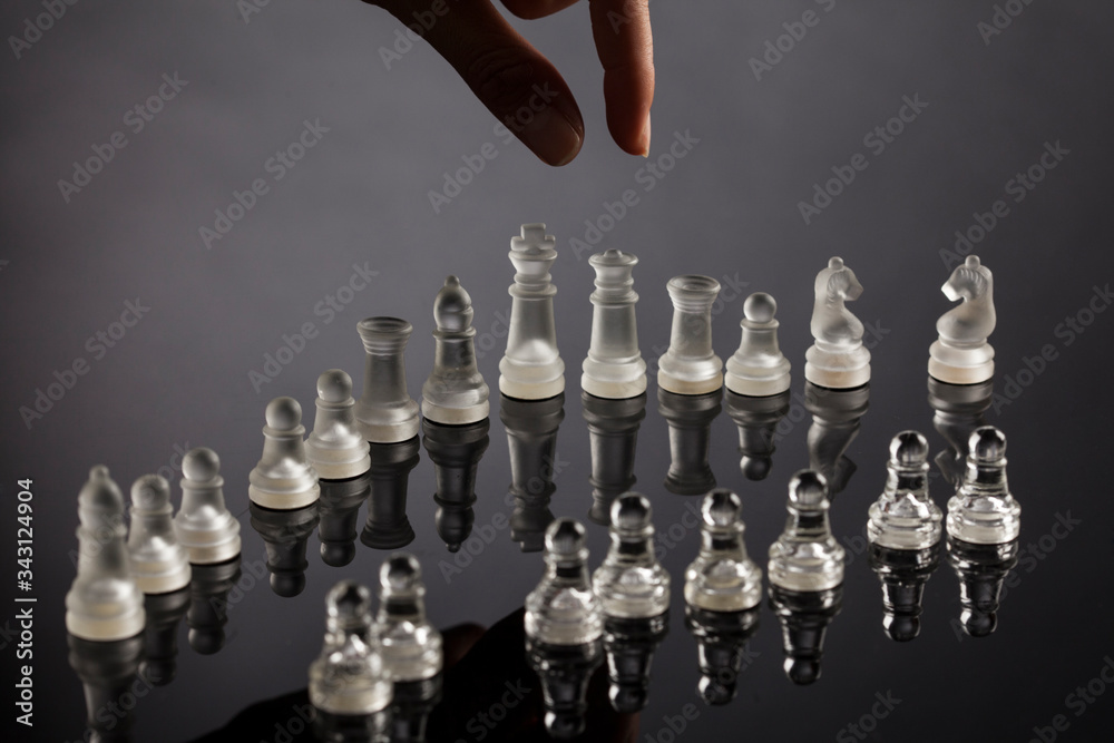 Pedine degli scacchi in vetro sulla scacchiera riflettono su superficie ...