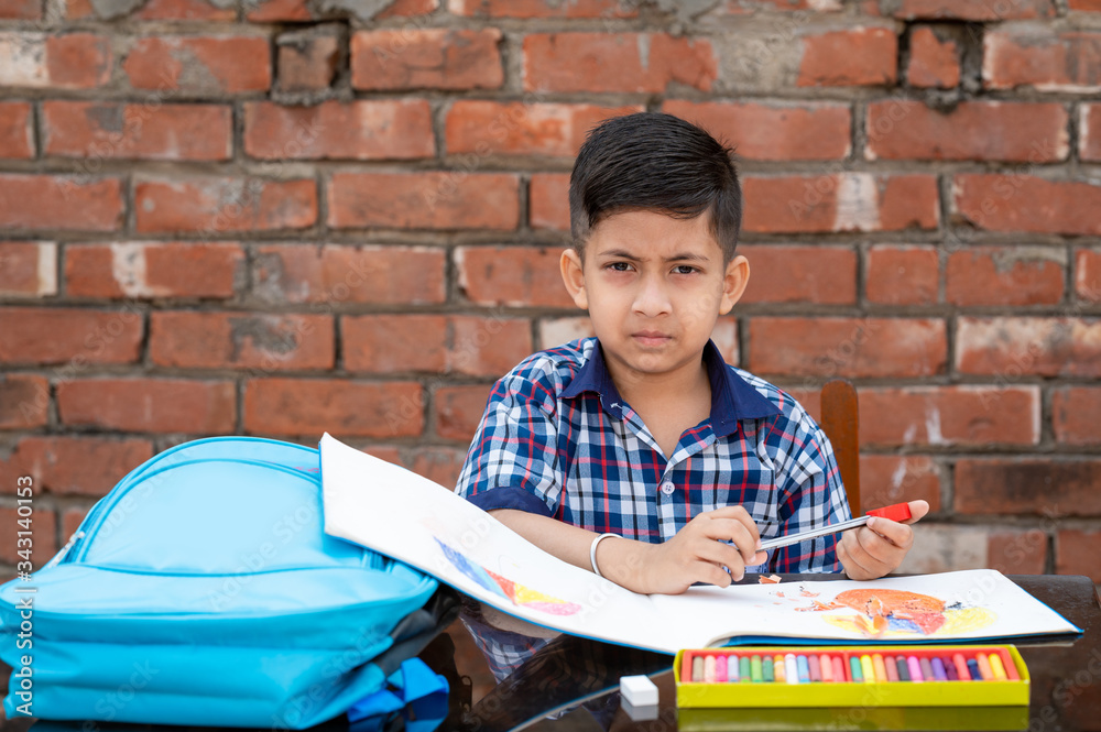 Indian schoolkid in uniform drawing and learning painting in classroom ...