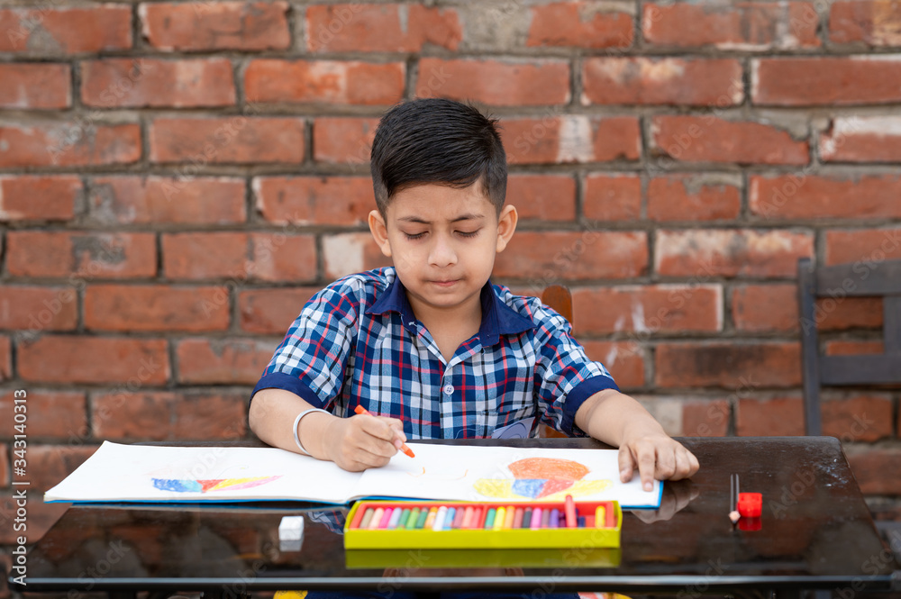 Indian schoolkid in uniform drawing and learning painting in classroom ...