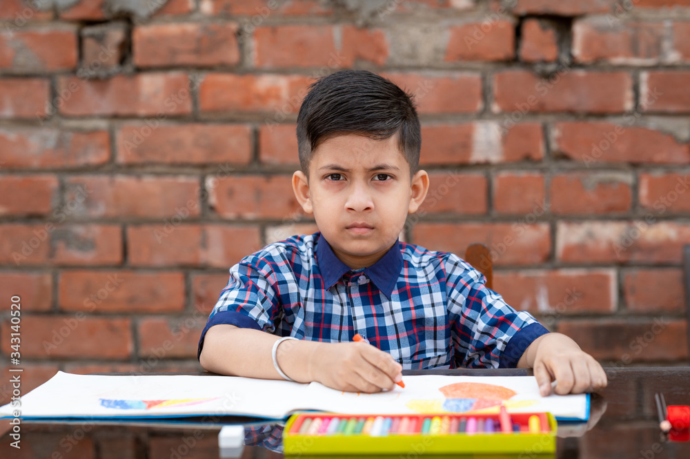 Indian schoolkid in uniform drawing and learning painting in classroom ...