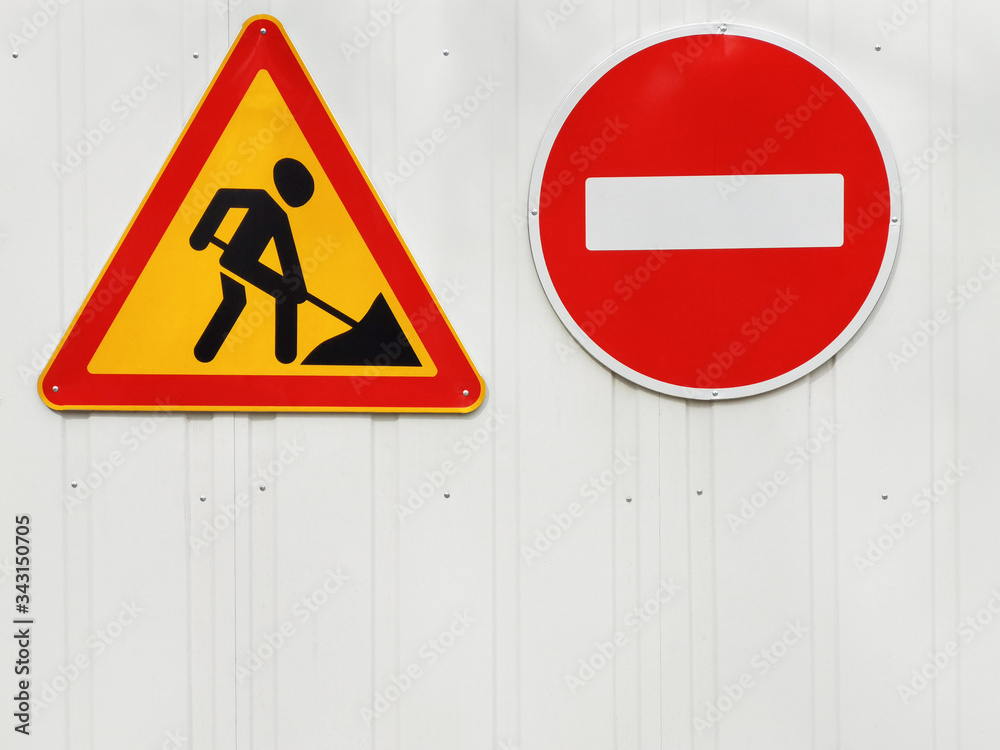 Warning signs on a white metal fence. Road works sign closeup. Stop ...