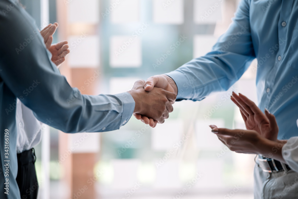 Teamwork of business people at meeting shaking hands to seal a deal ...