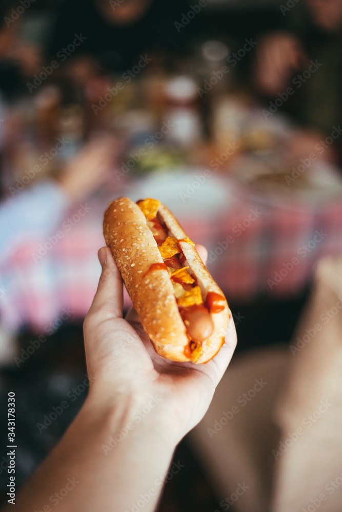 Hand taking a hot dog. Sausage, bun and mustard. Close up on delicious ...