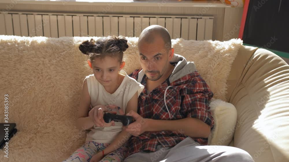 Happy father plays video games with cute kid daughter, family gamers ...