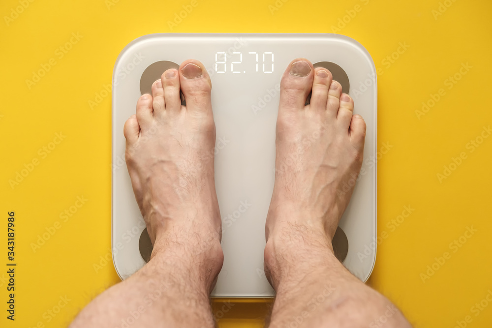 Male bare feet stand on smart scales that makes bioelectric impedance ...