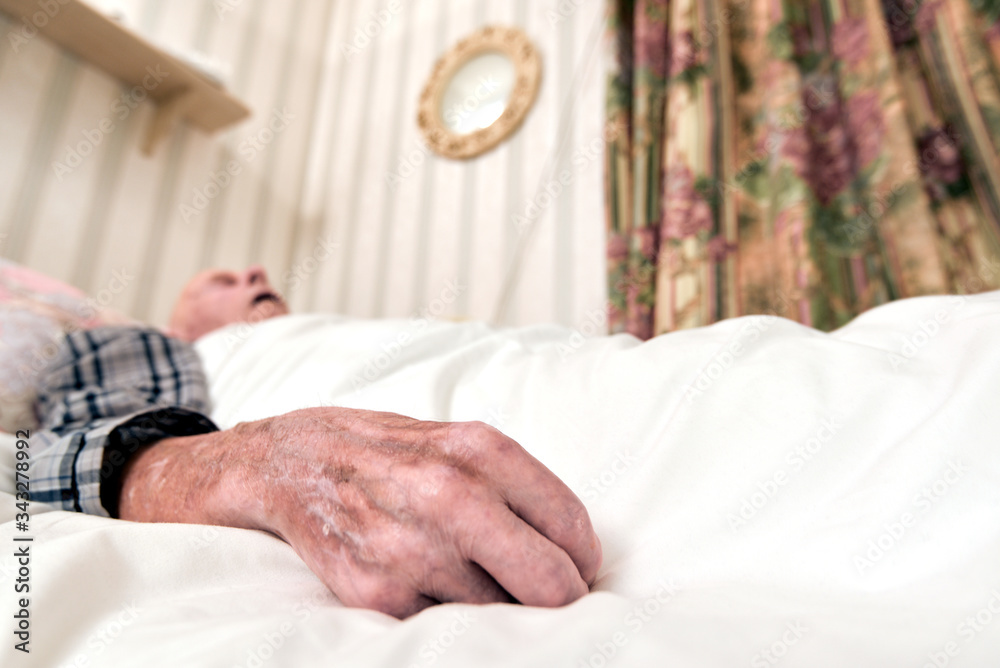 Elderly infirm man lying asleep in bed after being discharged from ...