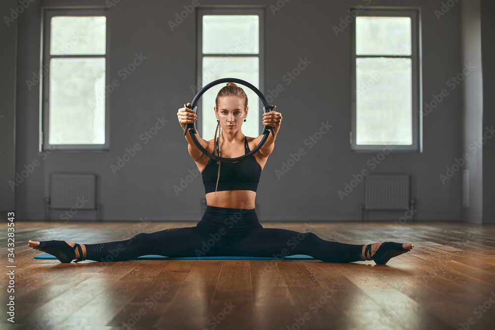 Fitness trainer with a beautiful figure poses for the camera during a ...
