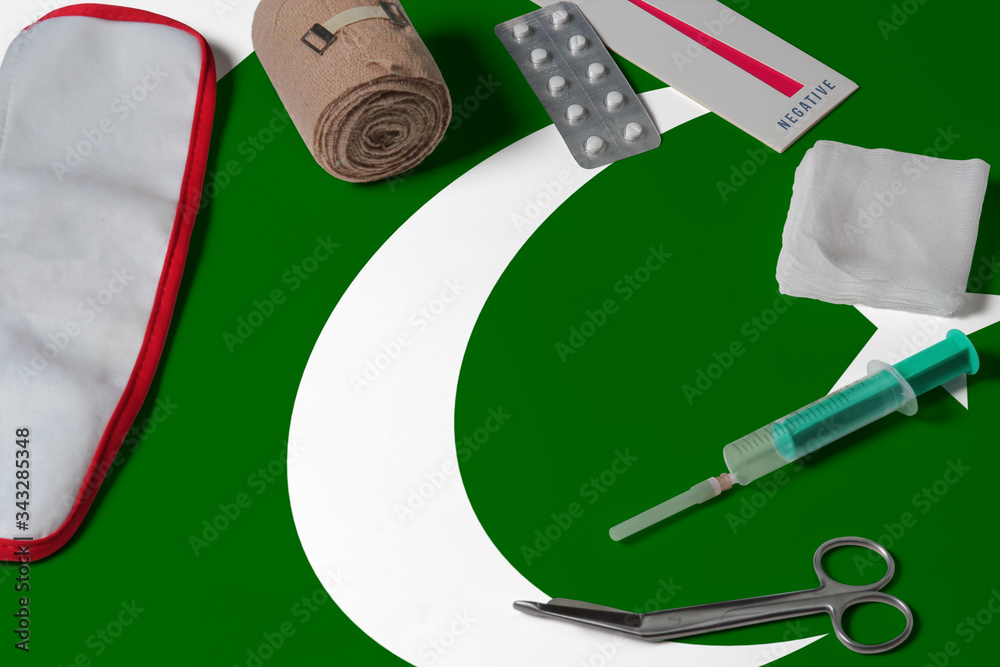 Pakistan flag with first aid medical kit on wooden table background ...