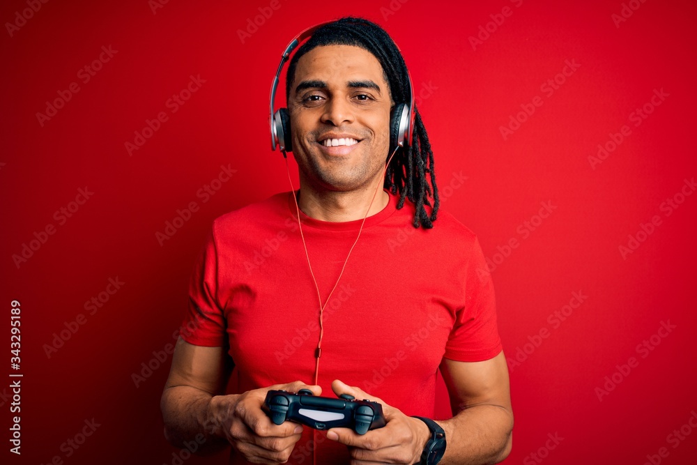 African american man with dreadlocks playing video game using joystick ...