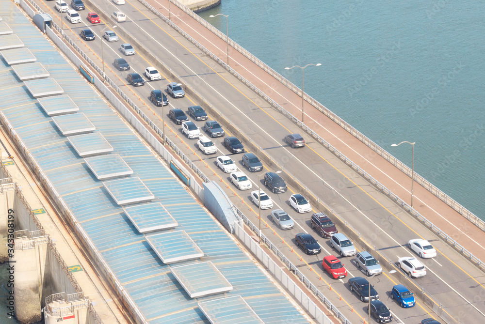 Traffic jam of cars on the bridge next to the sea, a view from above ...