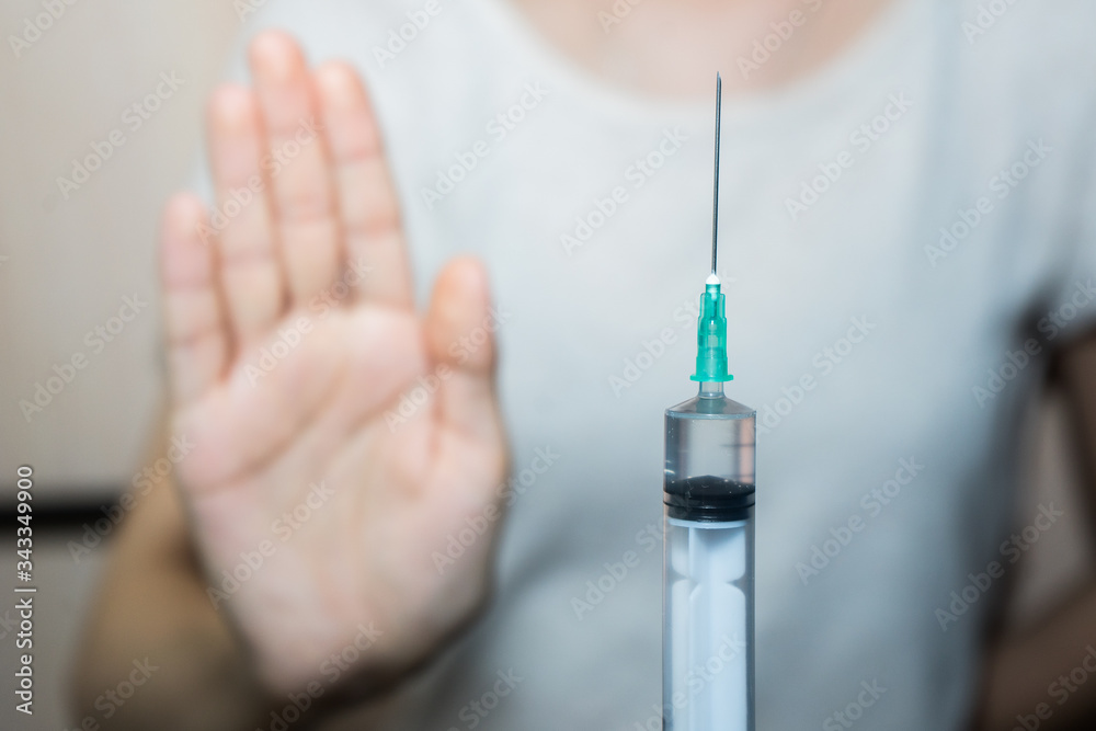 .Stop vaccinations. Say no to the coronavirus vaccines. A syringe in ...