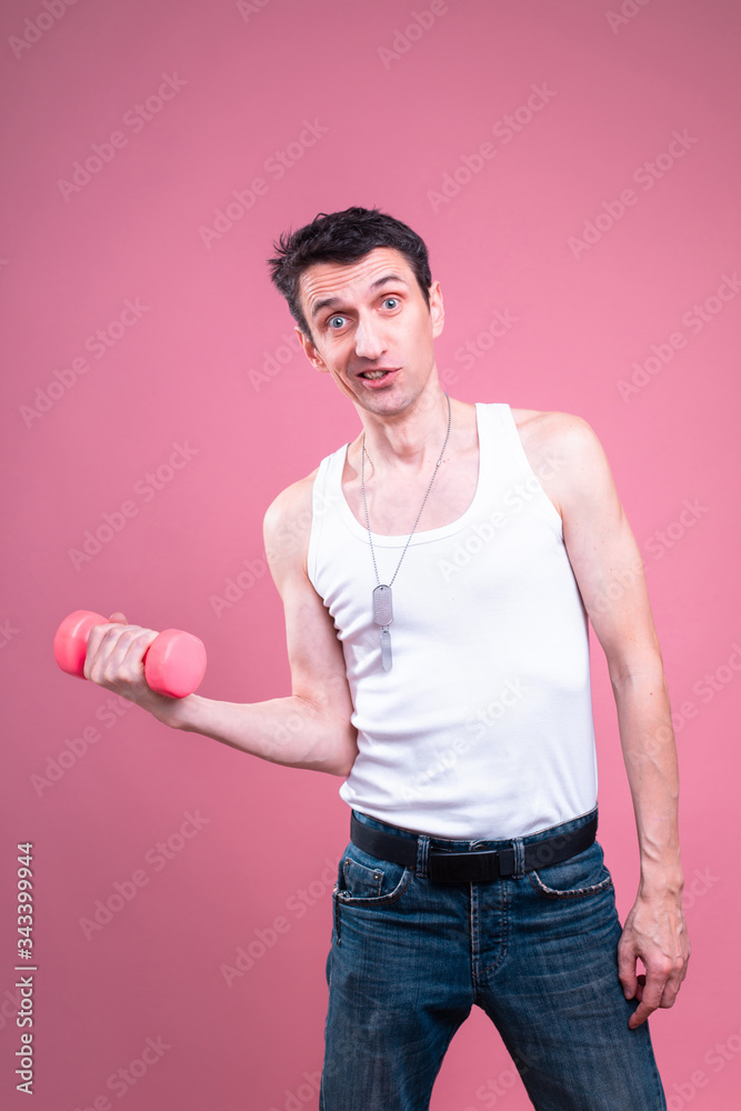 Vertical picture of emotional skinny man hold one dumbbell in hand and ...