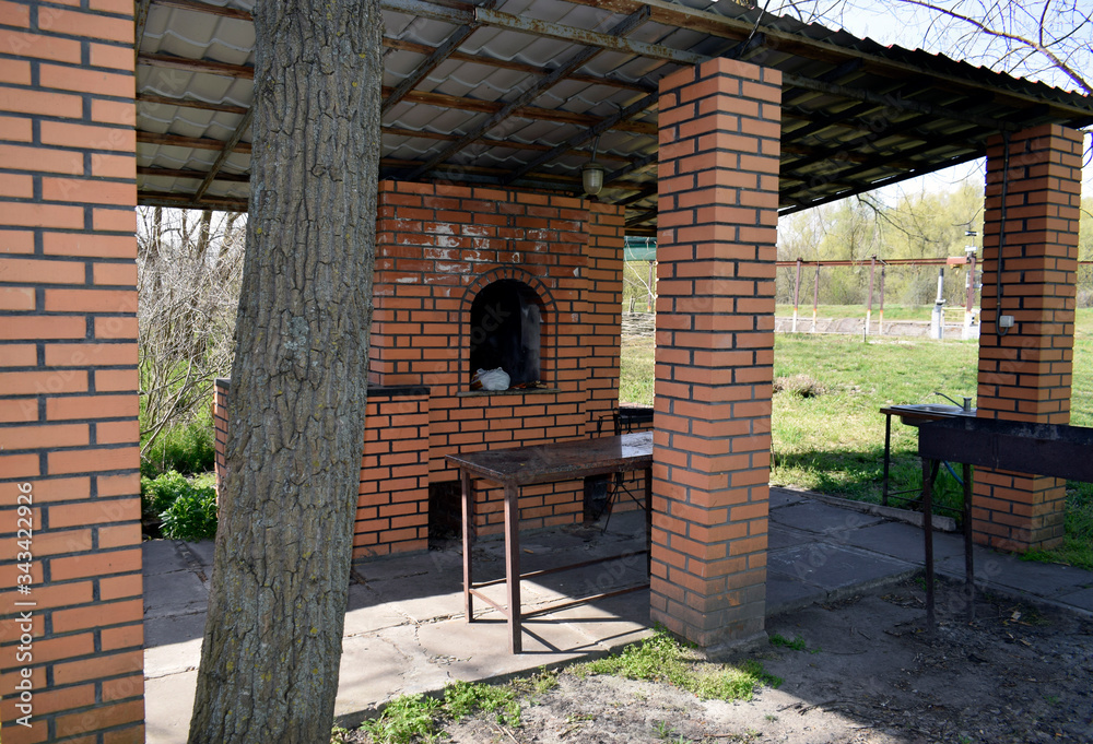 Oven, smokehouse and barbecue made of red stone. Construction with a ...