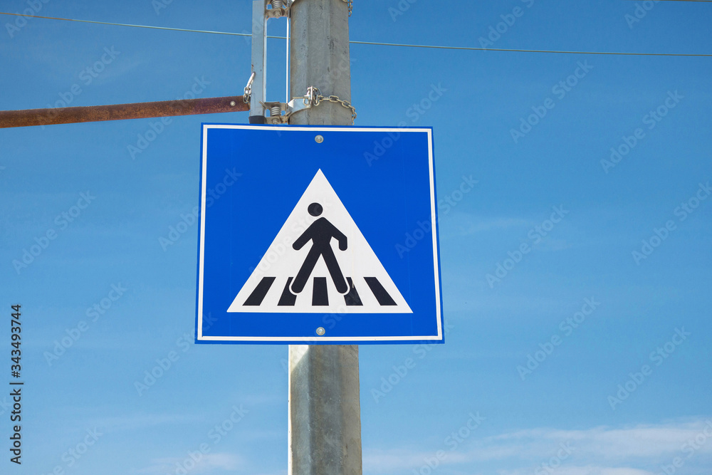 International traffic sign "Pedestrian crossing" on concrete pillar ...