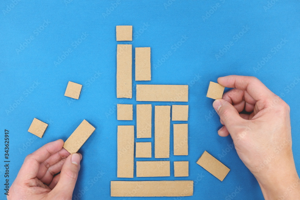 Nation rebuilding concept. Hands fixing fallen building blocks. Blue ...