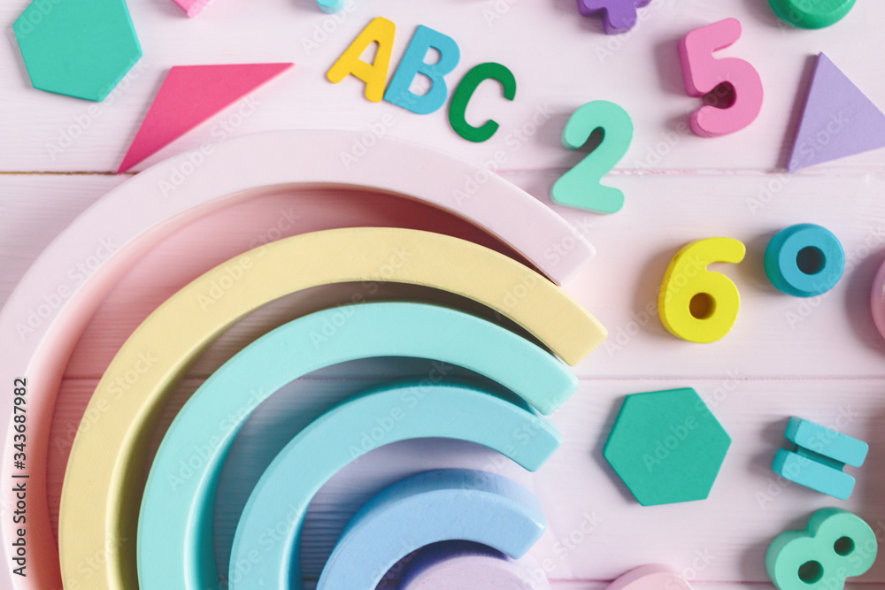 Wooden toy rainbow, numbers, blocks, pastel color arc on pink ...