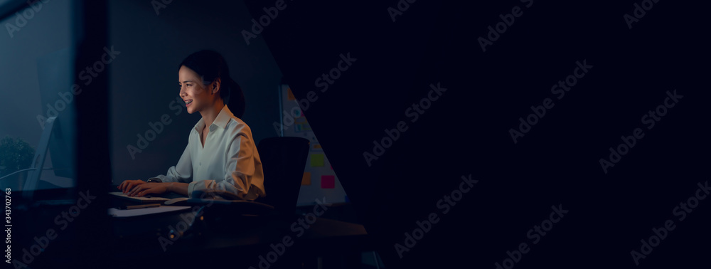 Smiling Asian business woman sitting the table and working on computer ...