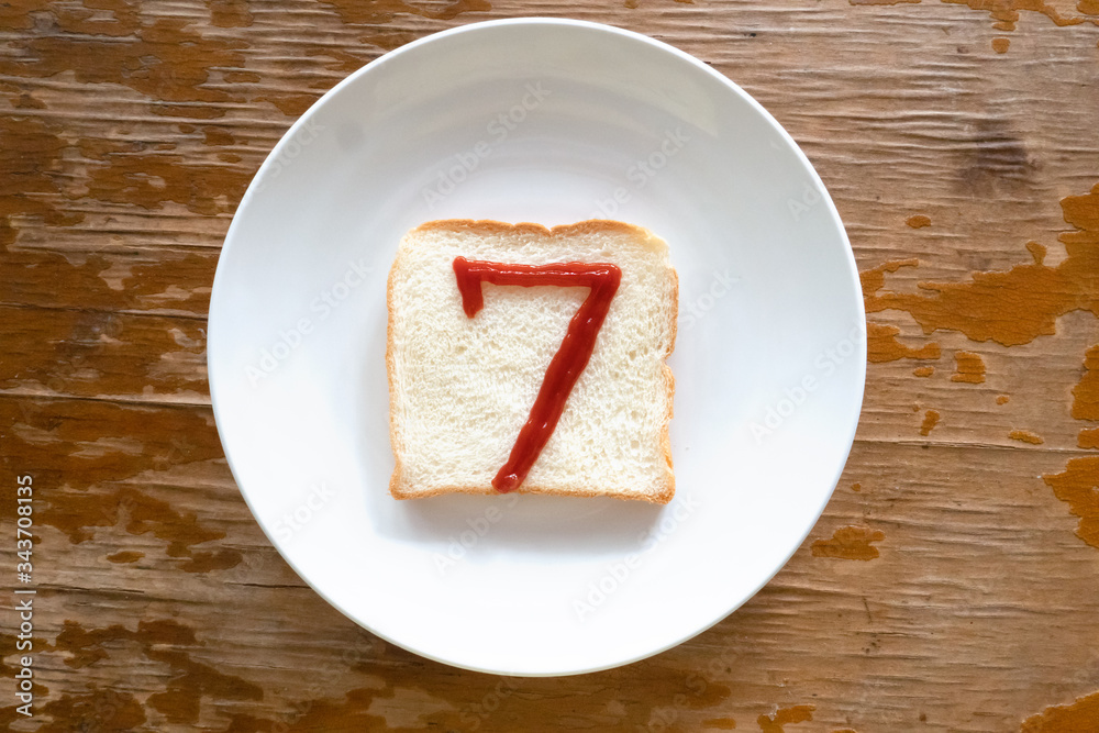 bread of breakfast is written number 7 by ketchup on write plate. A to ...