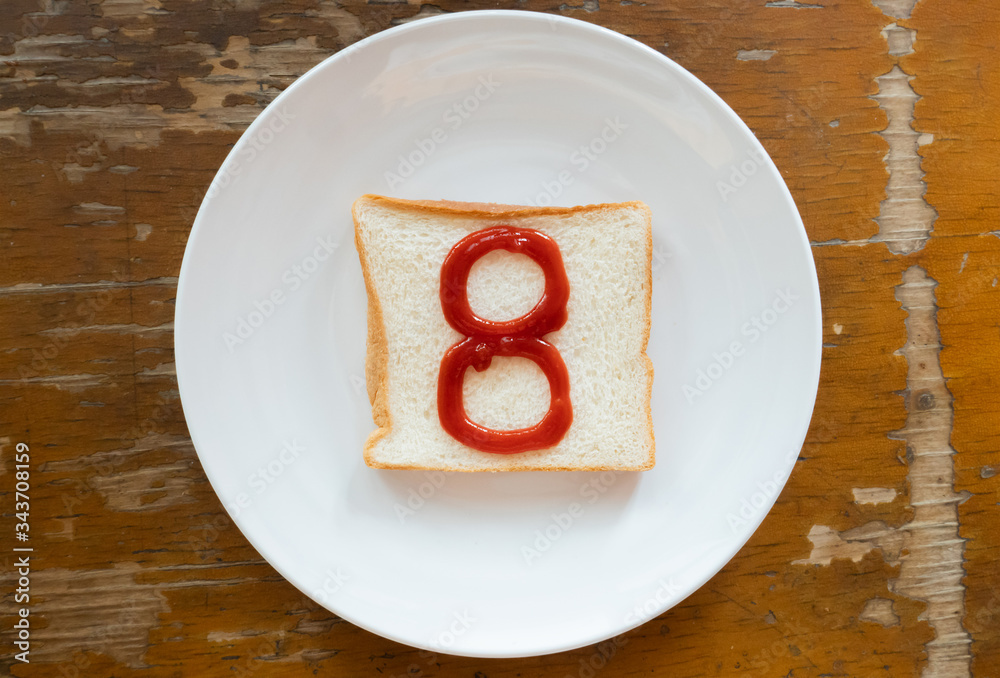 bread of breakfast is written number 8 by ketchup on write plate. A to ...