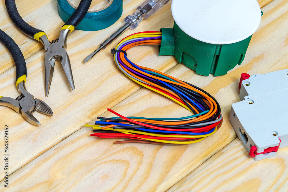 Electrical junction box with wires and tools on wooden boards usually ...