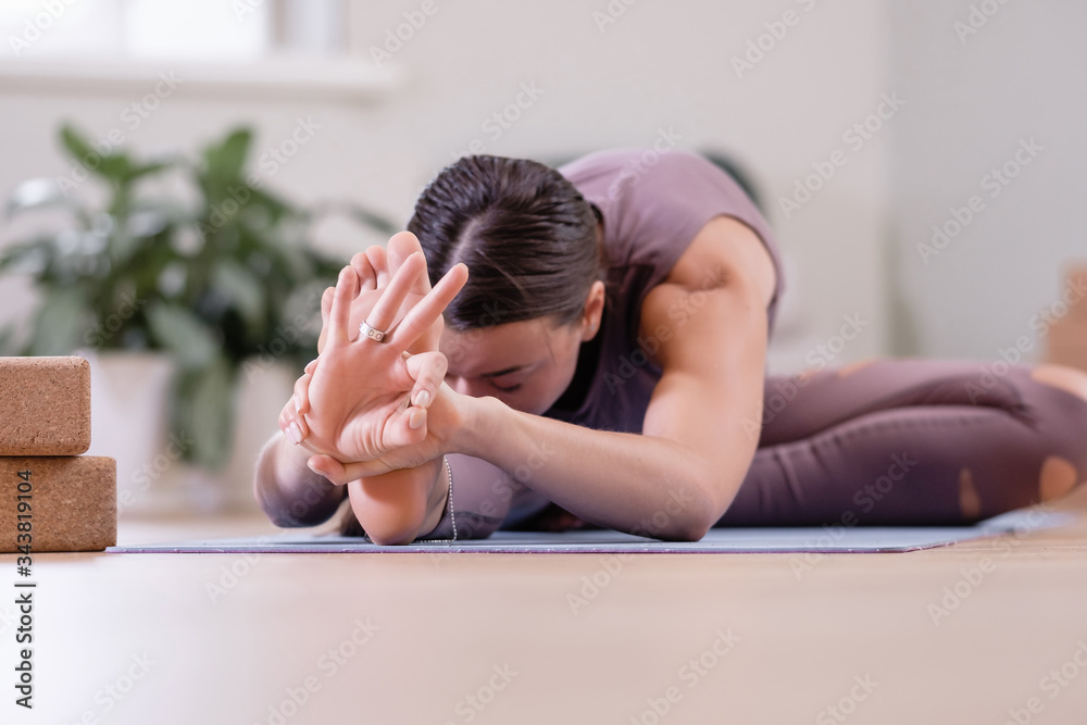 Calm spiritualized young woman yoga instructor meditates in the pose of ...
