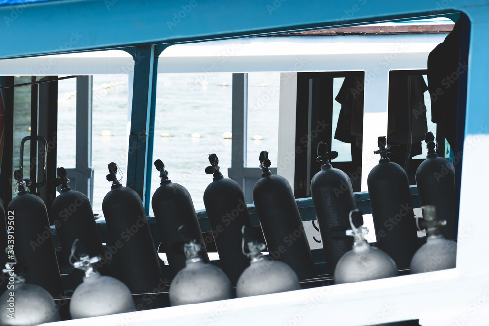 Scuba diving oxygen tanks in blue boat. Dark oxygen tanks is in camera ...