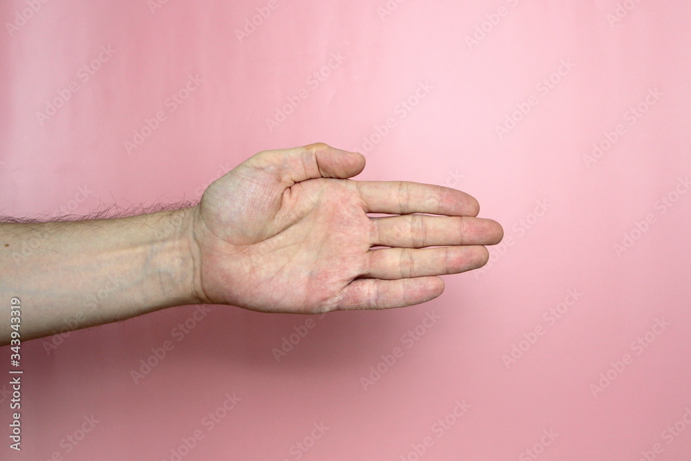 Male hand with fair skin shows a gesture, hand on a light pink ...