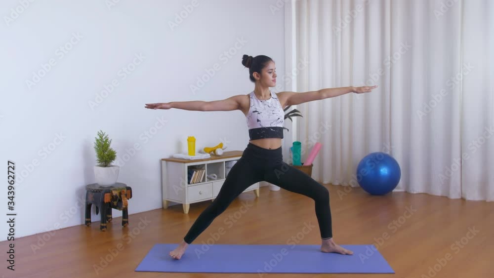 Vidéo Stock Young focused woman doing stretching exercises on a yoga ...
