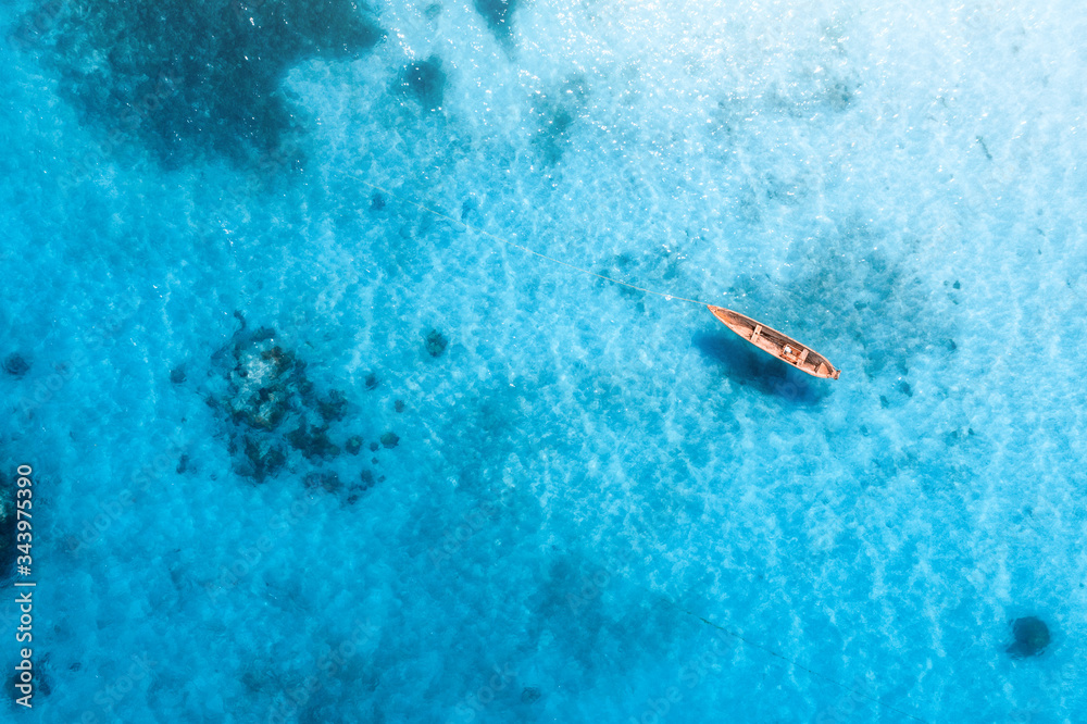 Aerial view of the fishing boat in transparent blue water at sunny day ...