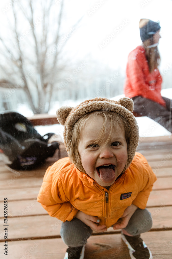 three year old smiling girl looks through window with tongue out Stock ...