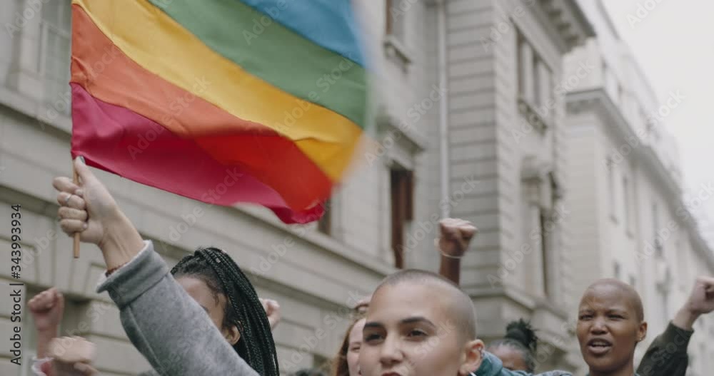 Young people participate in gay pride march. Woman holding a rainbow ...