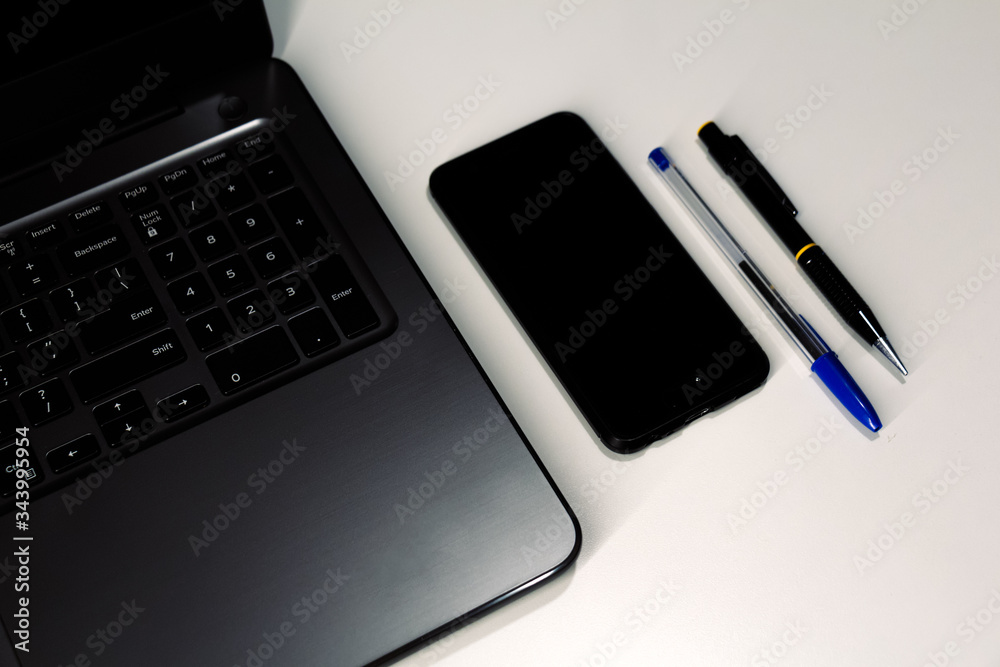 Vista en cenital de una laptop junto a un teléfono celular y un par de ...