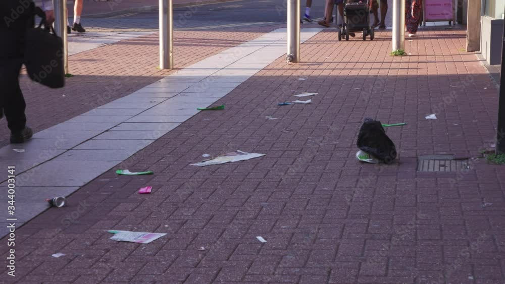 Litter, plastic bags and tin cans on the pavement of a British high ...