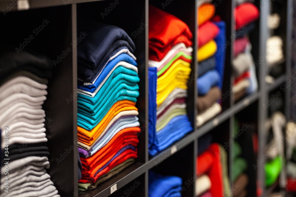 details of clothing and textile on display in clothing store folded ...