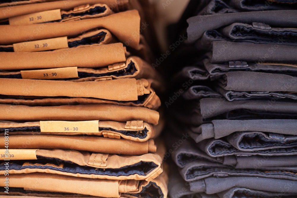 details of clothing and textile on display in clothing store folded ...