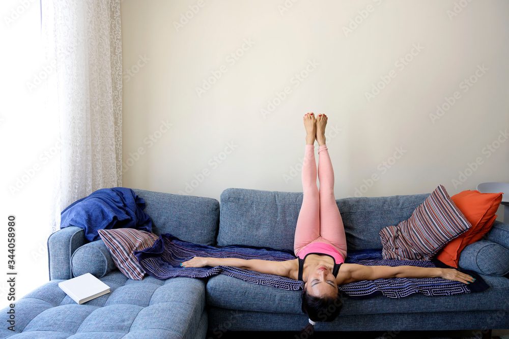 Woman relaxing lying on sofa feet up on wall background isolated Stock ...