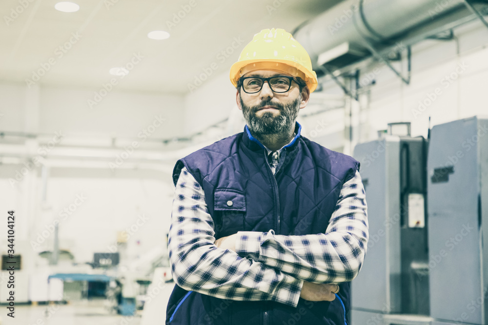 Indoor portrait of positive confident factory worker. Bearded middle ...