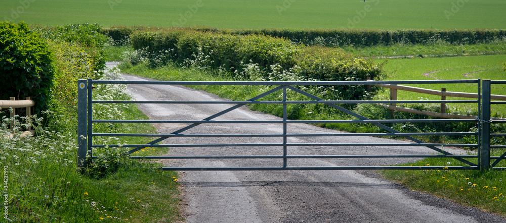 Gate across road blocking vehicular access to a farm whilst allowing ...