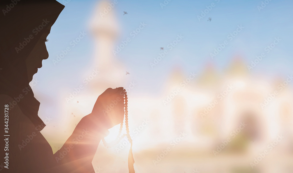 Young female muslim prayer with hijab praying to God front of blur ...