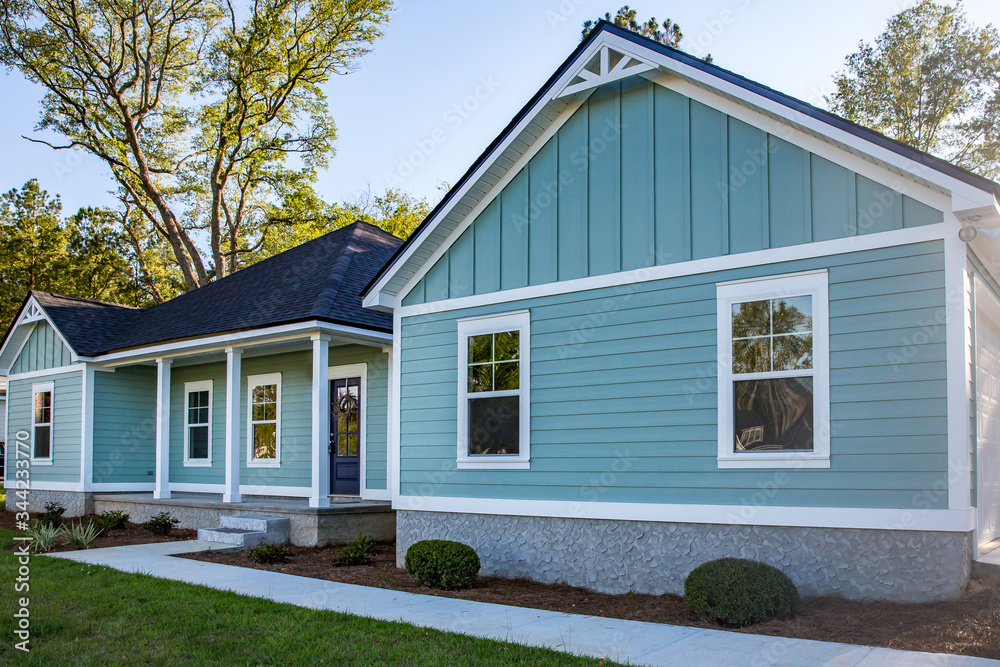 Front view of a brand new construction house with blue siding, a ranch ...