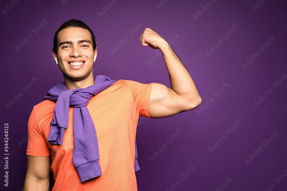 Portrait of young smiling and cheerful happy man showing his biceps ...