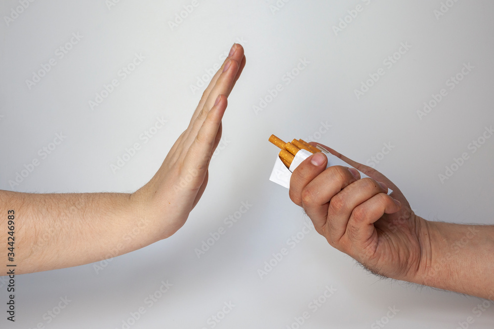 Foto de Giving up cigarettes. The man hands the cigarettes in the pack ...